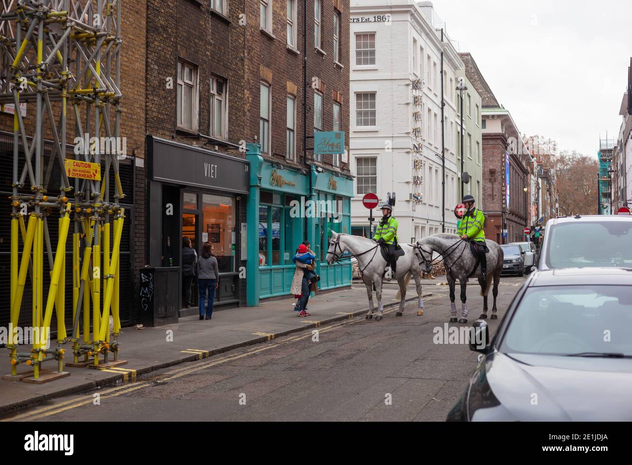 Britain in Pandemic - Street view of a woman and child and two mounted ...