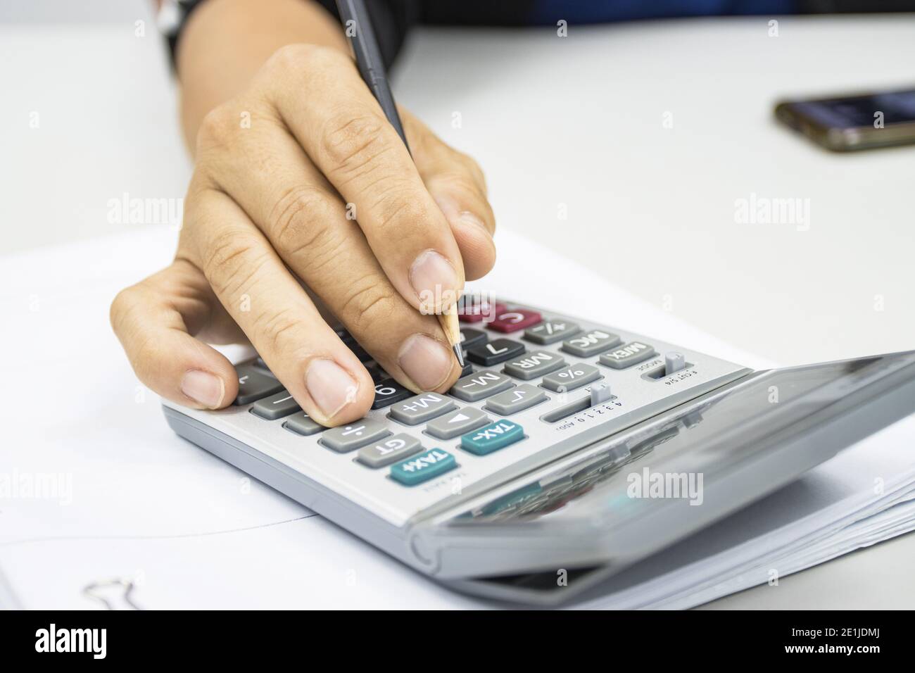 hand of man use a calculator to calculate income and expenses in the ...