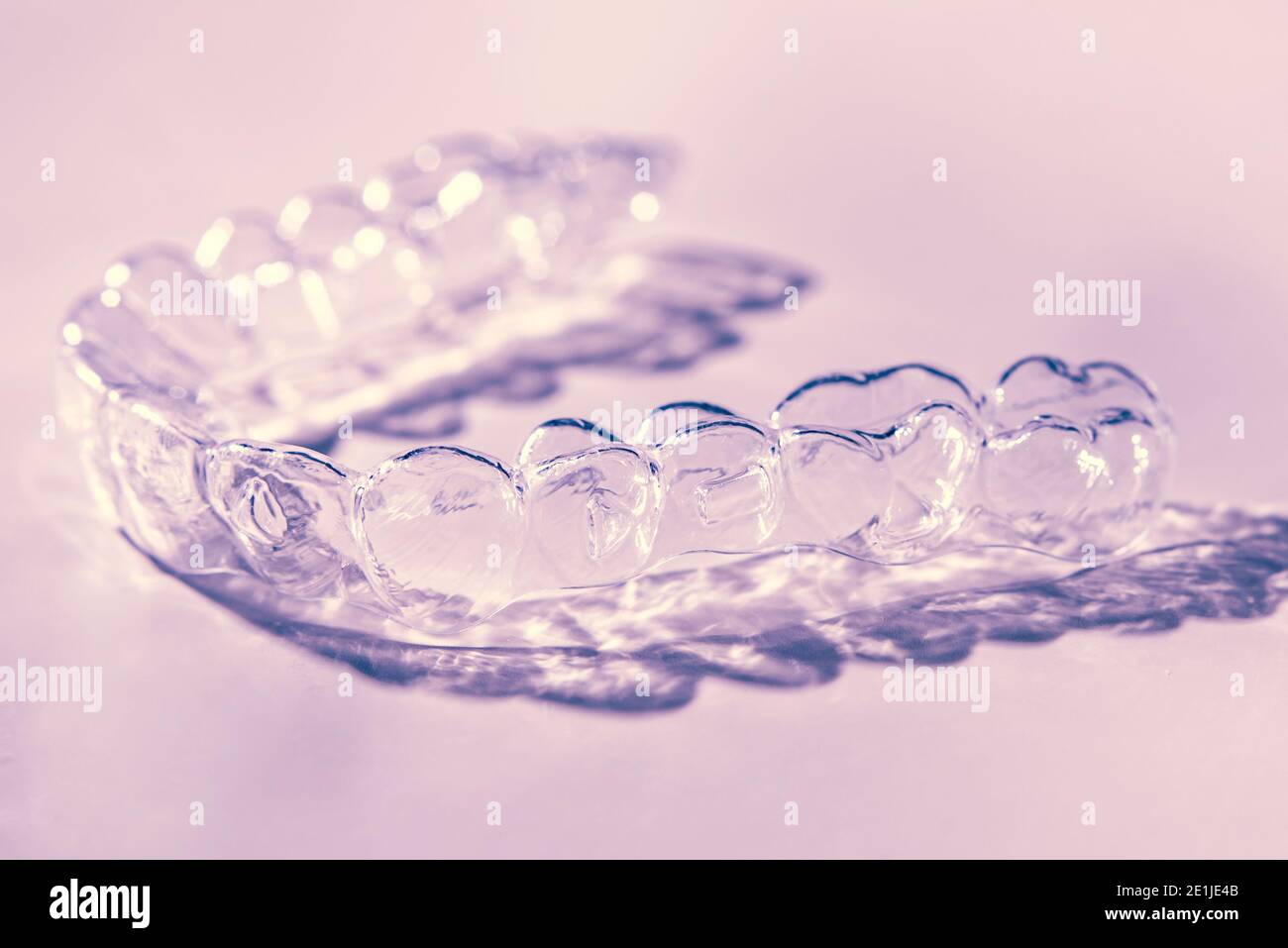 Invisible aligner teeth retainers on a pink background Stock Photo - Alamy
