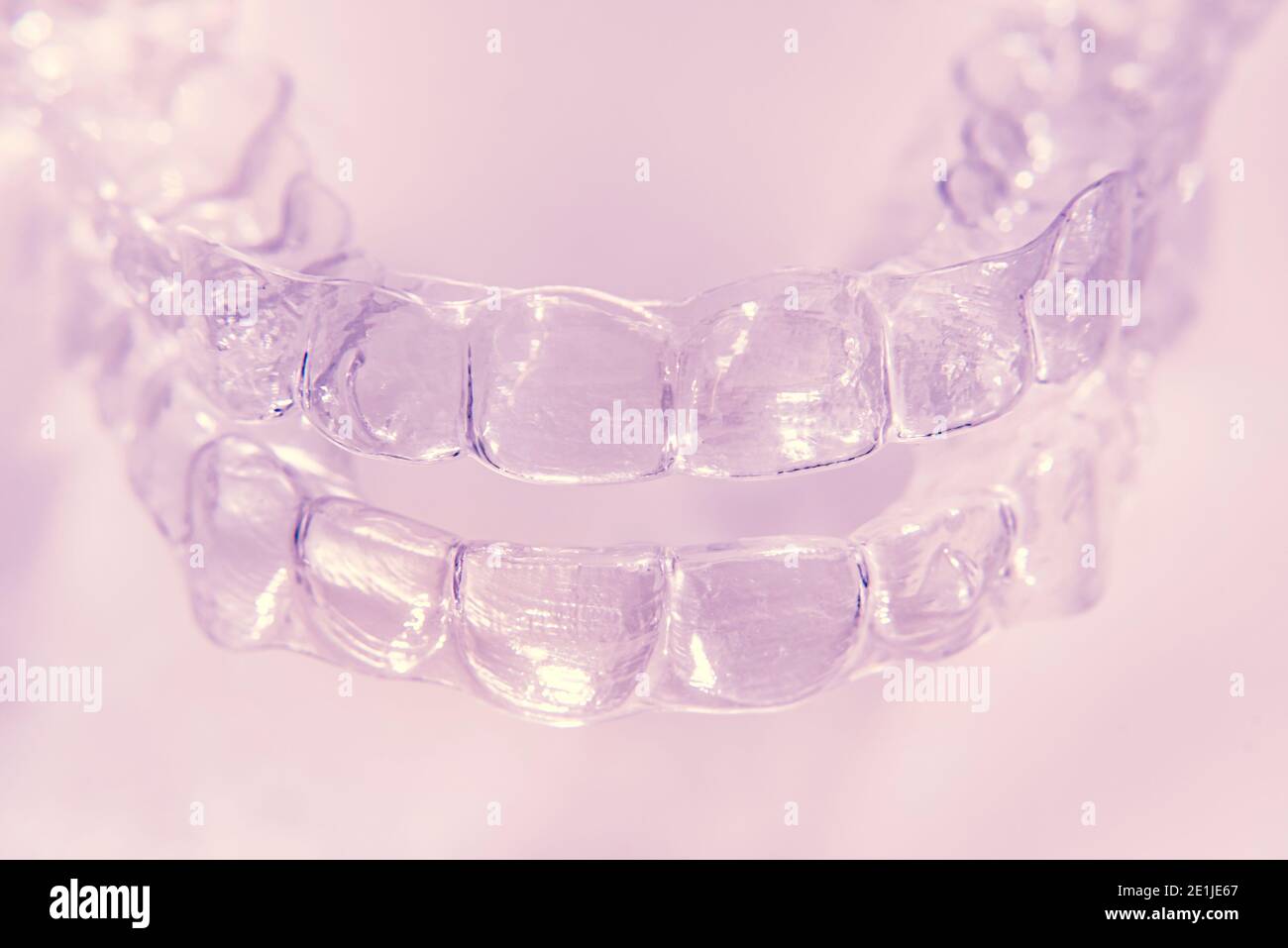 Invisible aligner teeth retainers on a pink background Stock Photo - Alamy
