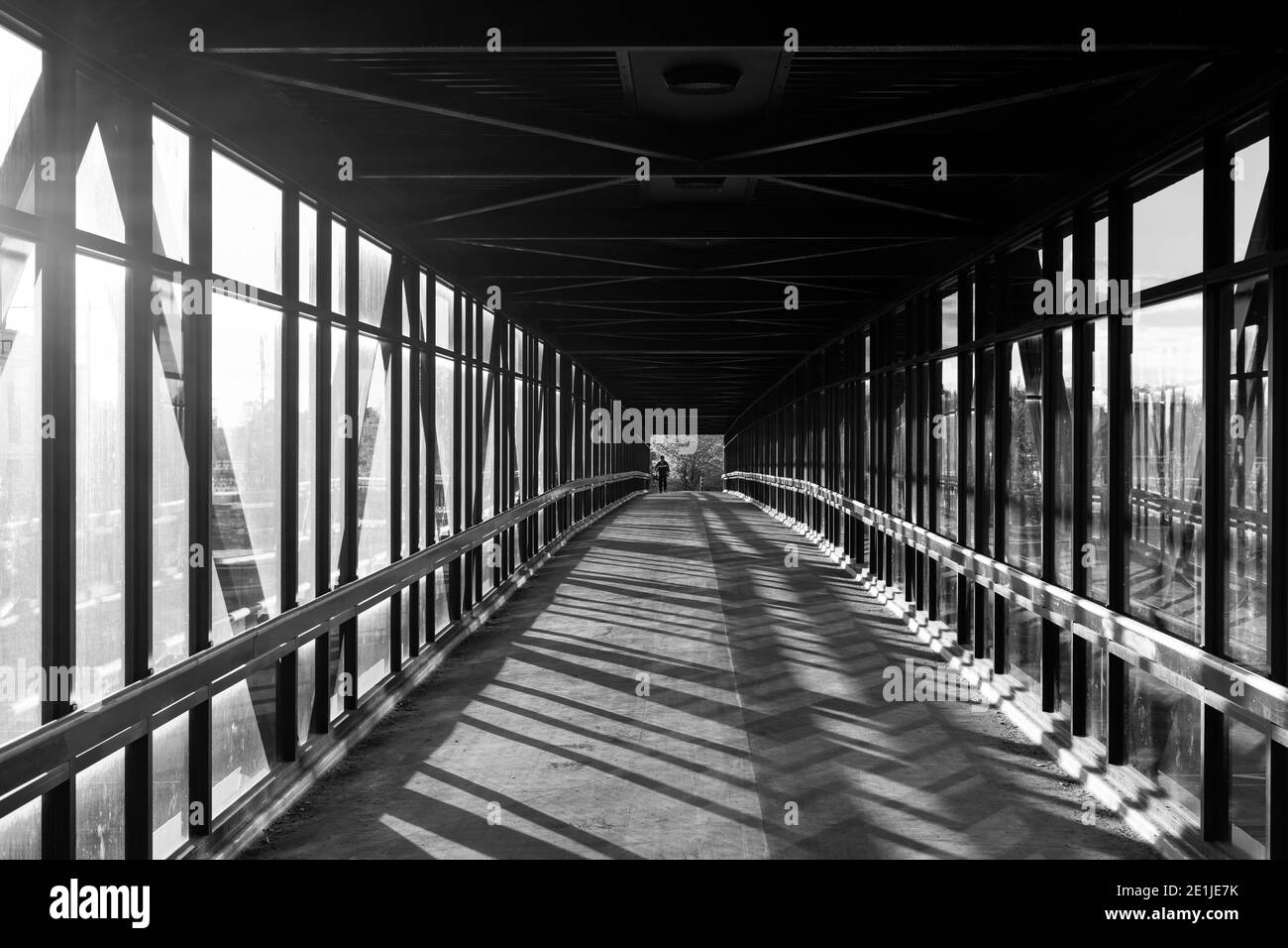 pedestrian pathway above highway, golden light shining creating shadows ...