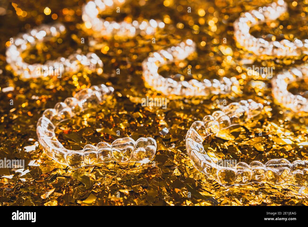 Invisible dental teeth brackets tooth aligners on gold background ...