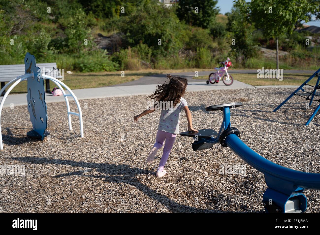 Young girl in pink clothes and running in a park seen from behind Stock ...