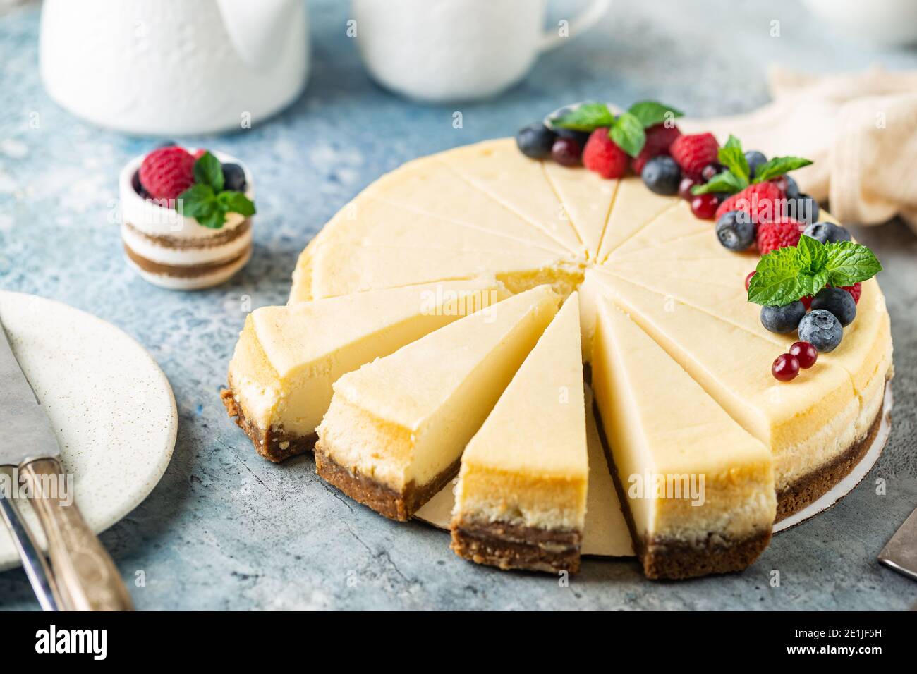 Classic New York cheesecake with fresh berries on light blue concrete ...