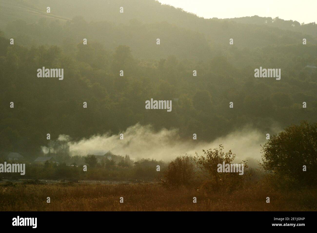 Landscape in Romania's countryside. Smoke coming out from a field ...