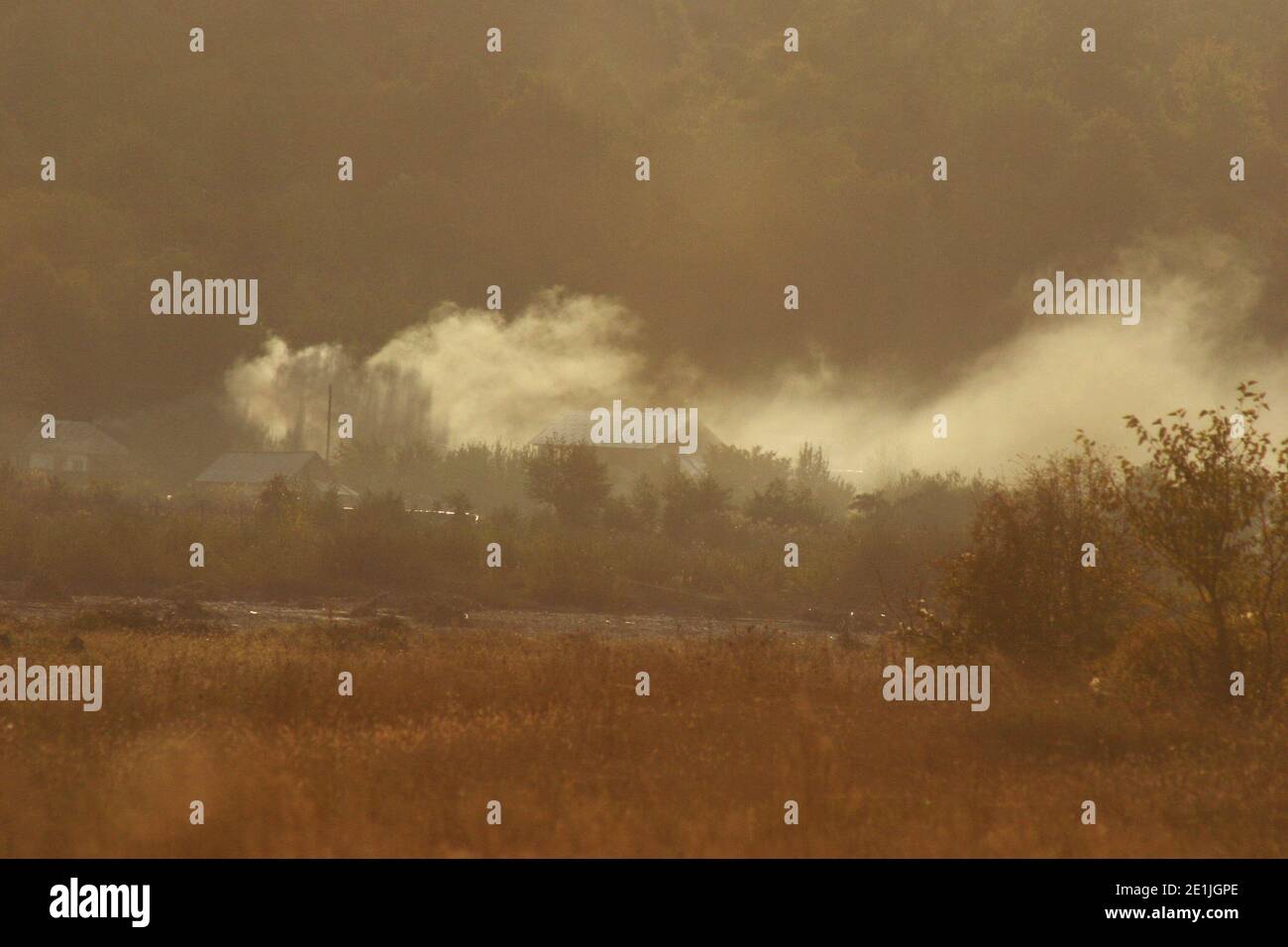 Landscape in Romania's countryside. Smoke coming out from a field ...