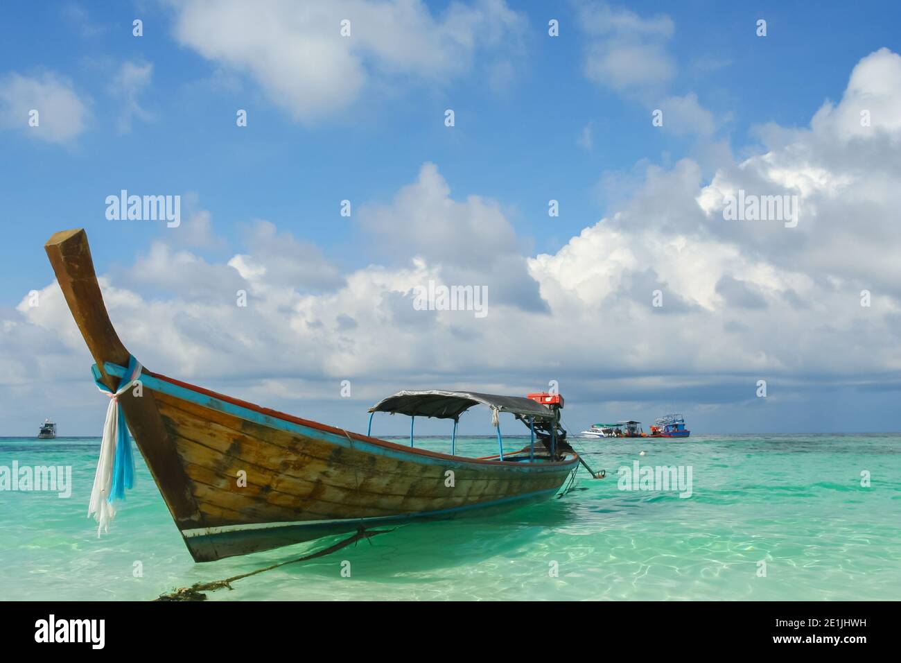 Long boat floating on tropical beach Stock Photo - Alamy