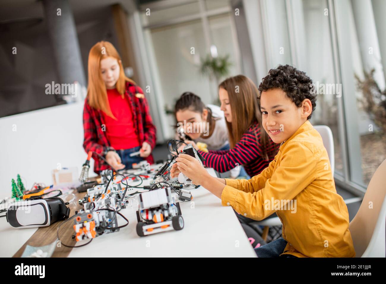 Group of happy kids programming electric toys and robots at robotics ...