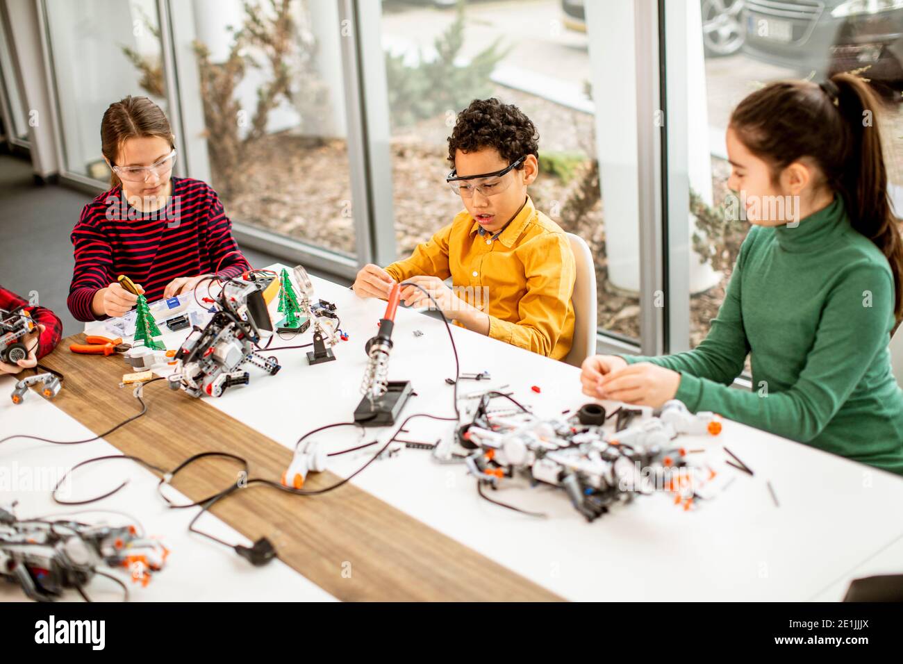 Group of happy kids programming electric toys and robots at robotics ...