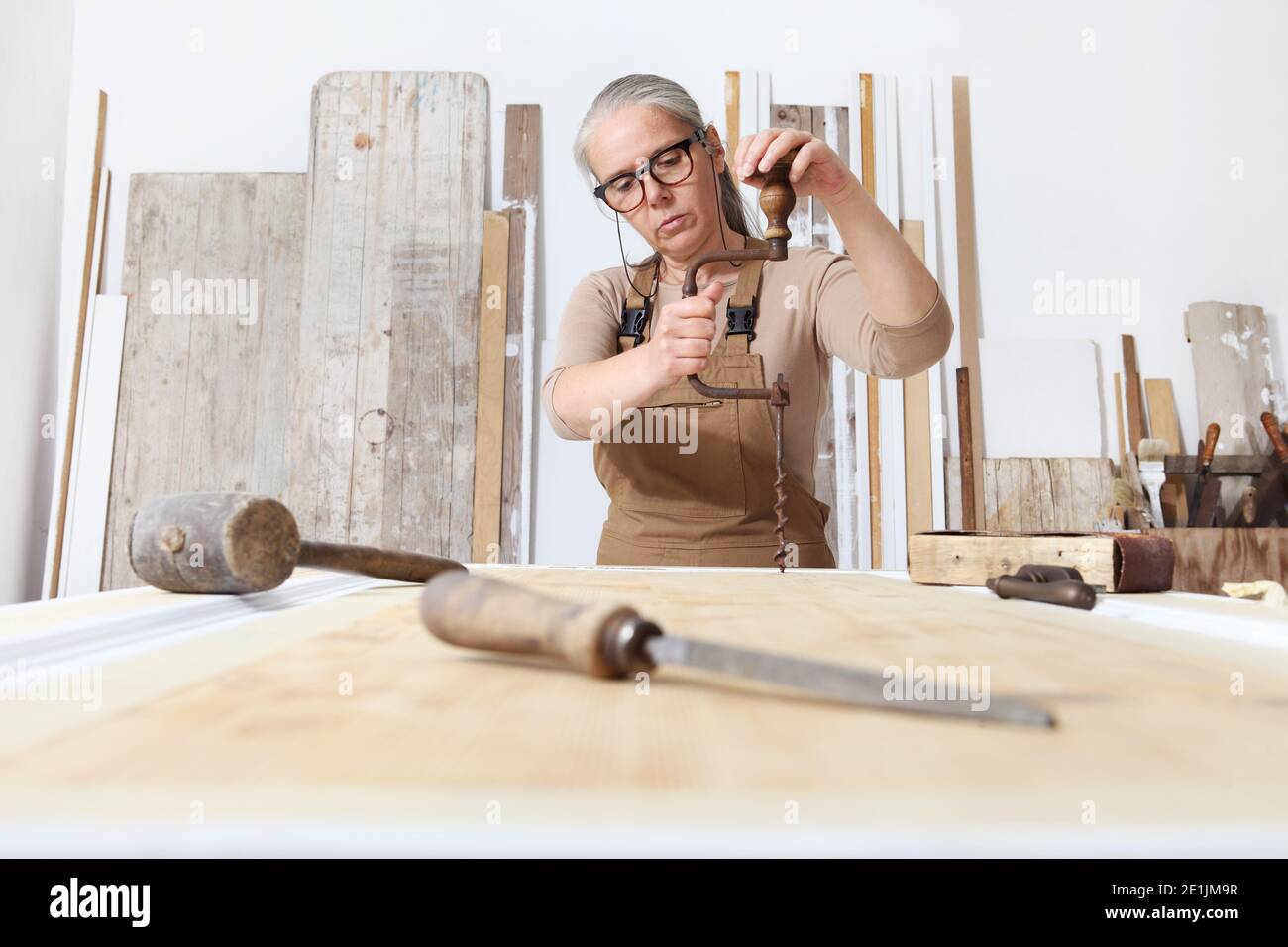 wood crafts, woman artisan carpenter works wood with old manual tools ...
