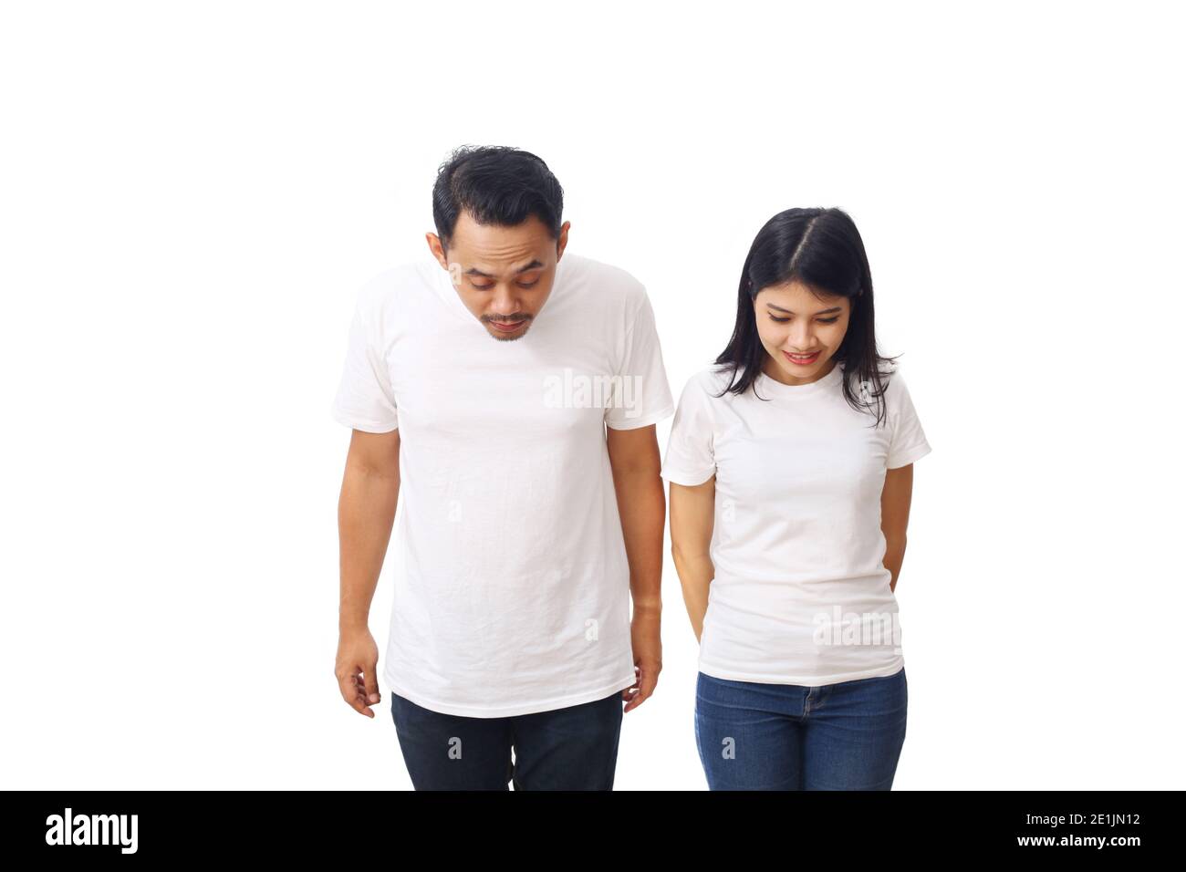 Happy asian couple in white shirt looking something below them ...