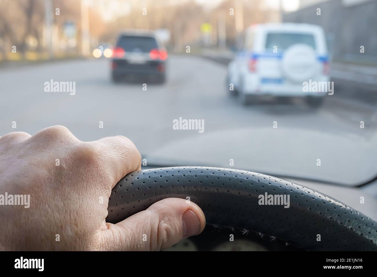 the driver's hand on the steering wheel of a car that is driving on the ...