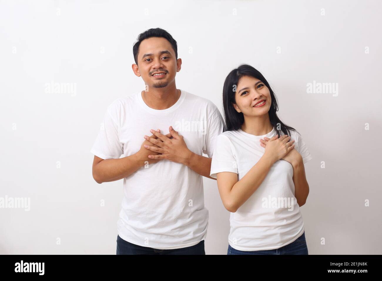 Portrait of peaceful, faithful asian couple in white shirt. They touch ...