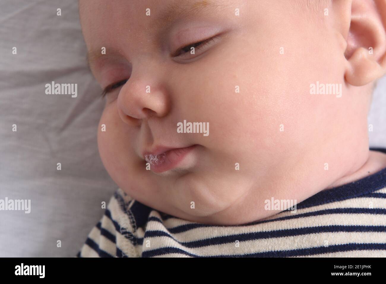 relaxed baby with drool in the mouth, side view Stock Photo - Alamy