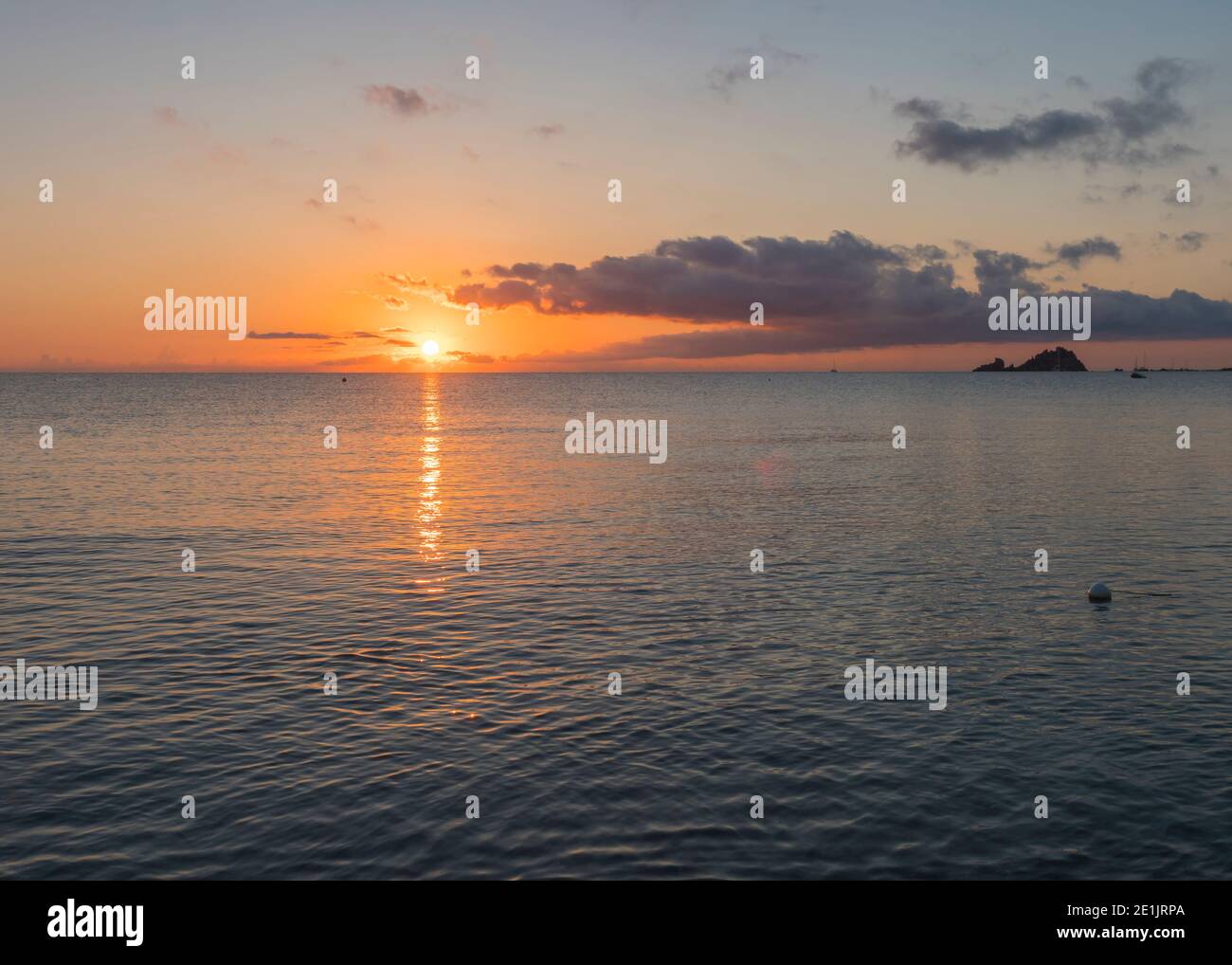 Sunrise with the red orange sun raising up from the sea with dark ...