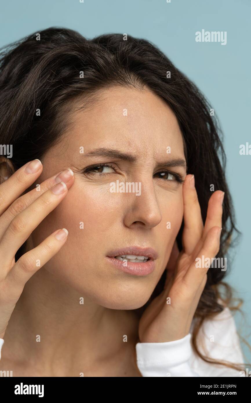 Worried woman has signs of aging skin, checking crows feet troubled ...