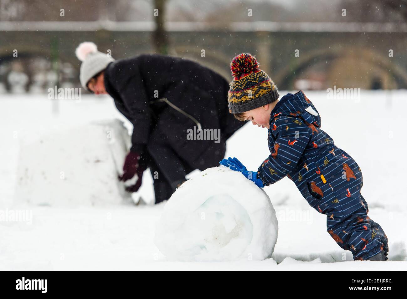3 year old Frankie and mother Wendy Dunn roll a snowman together in ...