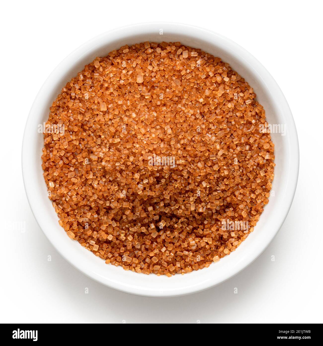 Dark brown granulated sugar in white ceramic bowl isolated on white ...
