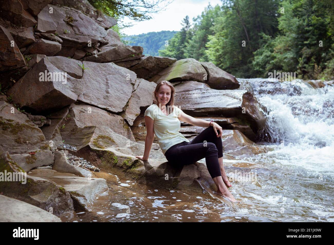 Young girl sitting waterfall hi-res stock photography and images - Alamy