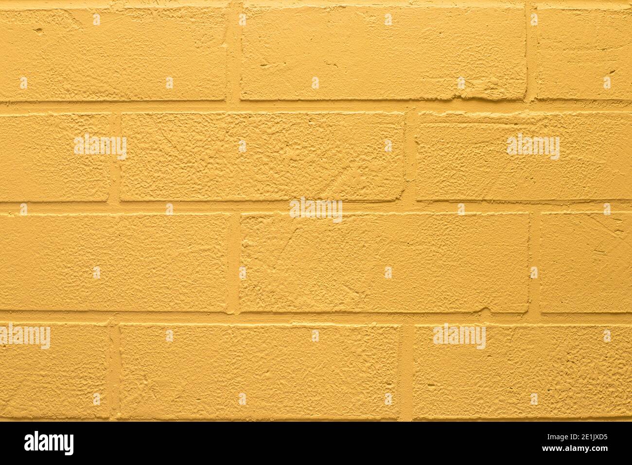 Brick wall. Decorative plaster in the form of a brick, painted yellow ...