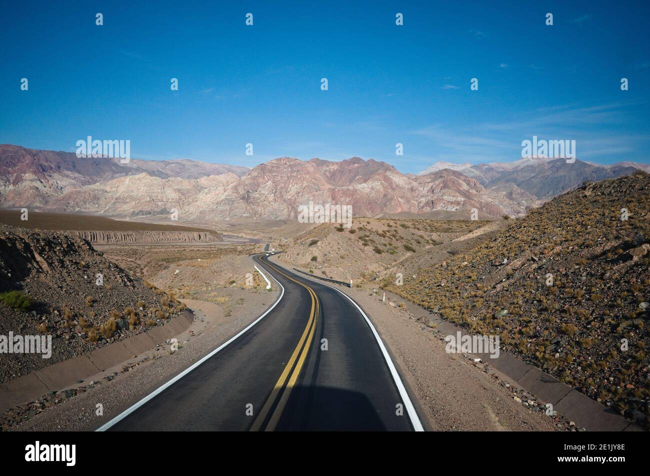 Empty asphalt highway road with curves and yellow dividing line in a ...