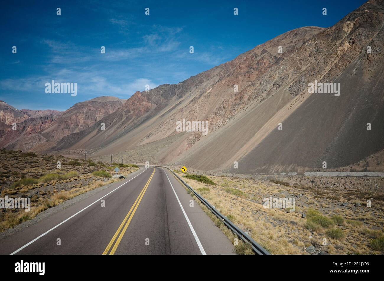 Empty asphalt highway road with curves and yellow dividing line in a ...
