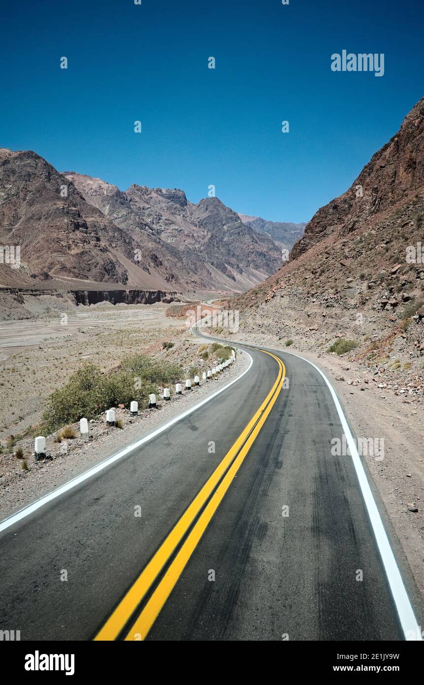 Empty asphalt highway road with curves and yellow dividing line in a ...