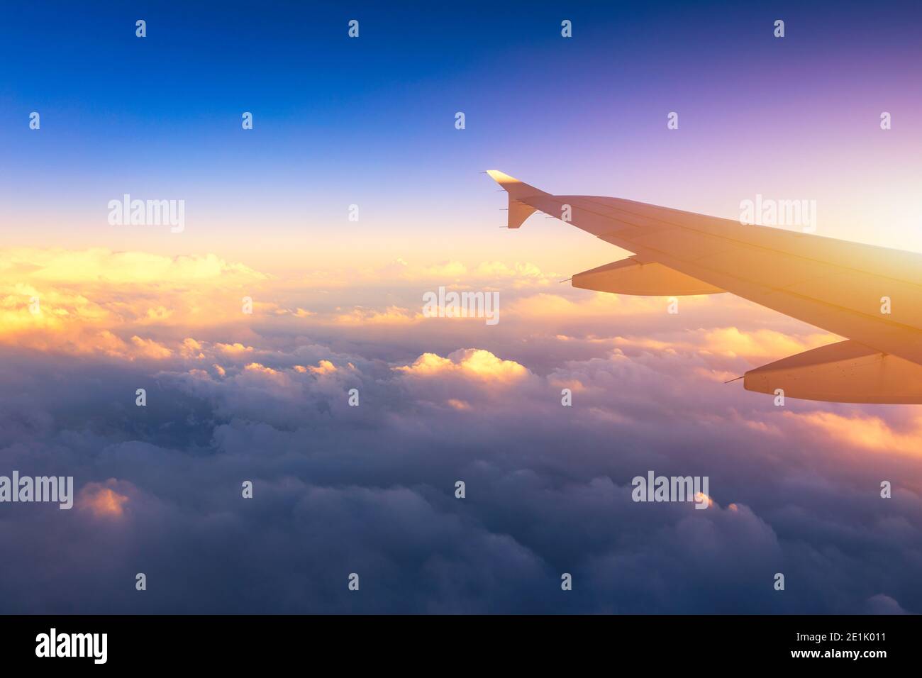 Flying and traveling, view from airplane window on the wing on sunset ...