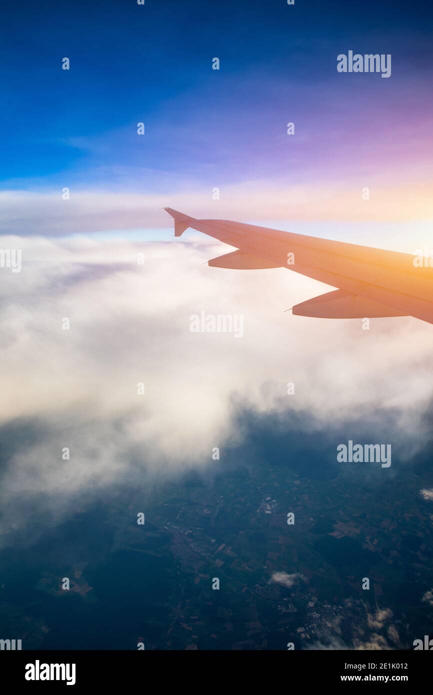 Flying and traveling, view from airplane window on the wing on sunset ...