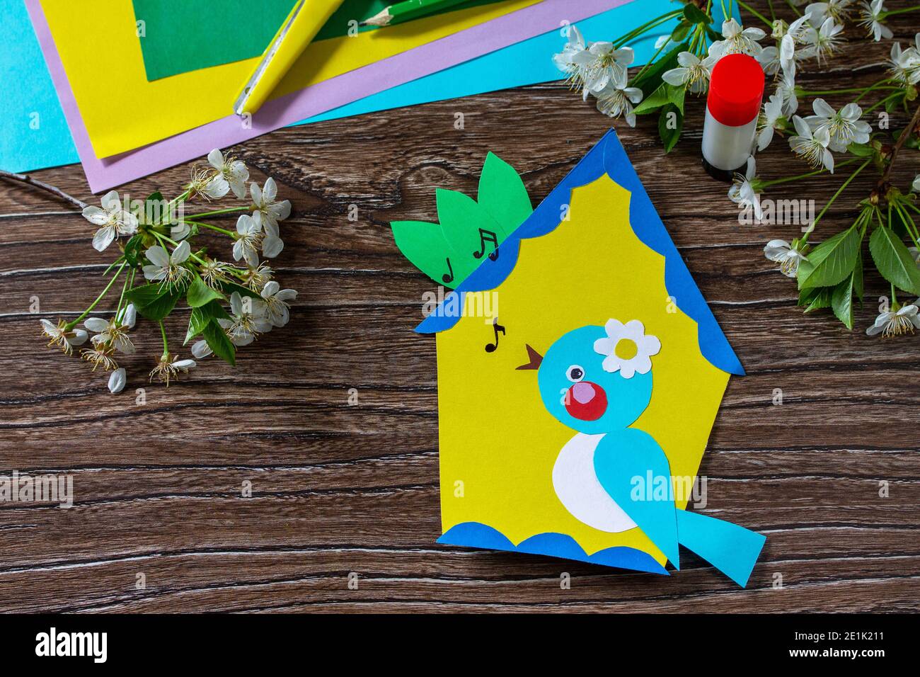 Spring postcard birdhouse with a bird on a wooden table. Handmade ...