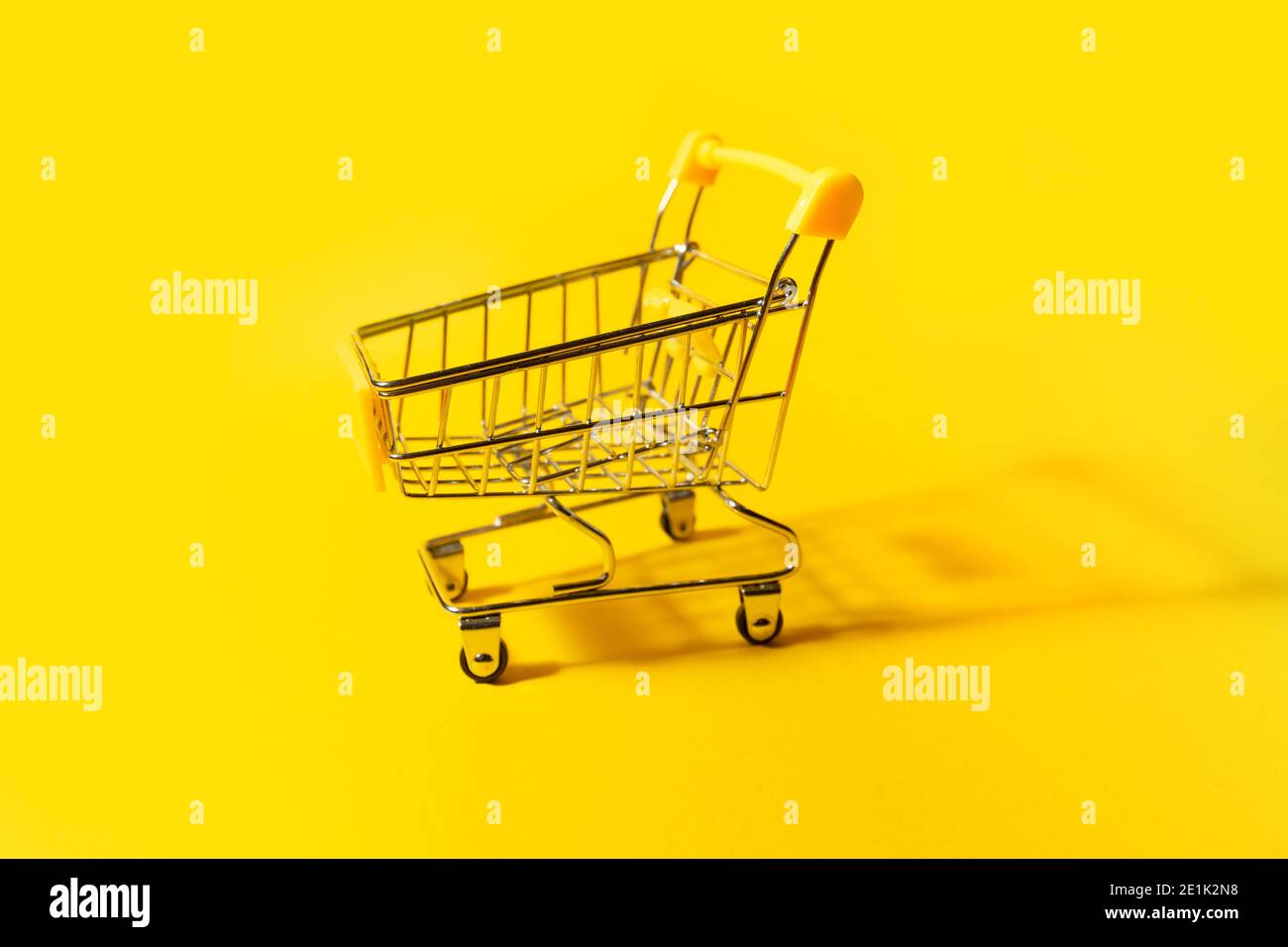 yellow shopping cart on yellow background Stock Photo - Alamy
