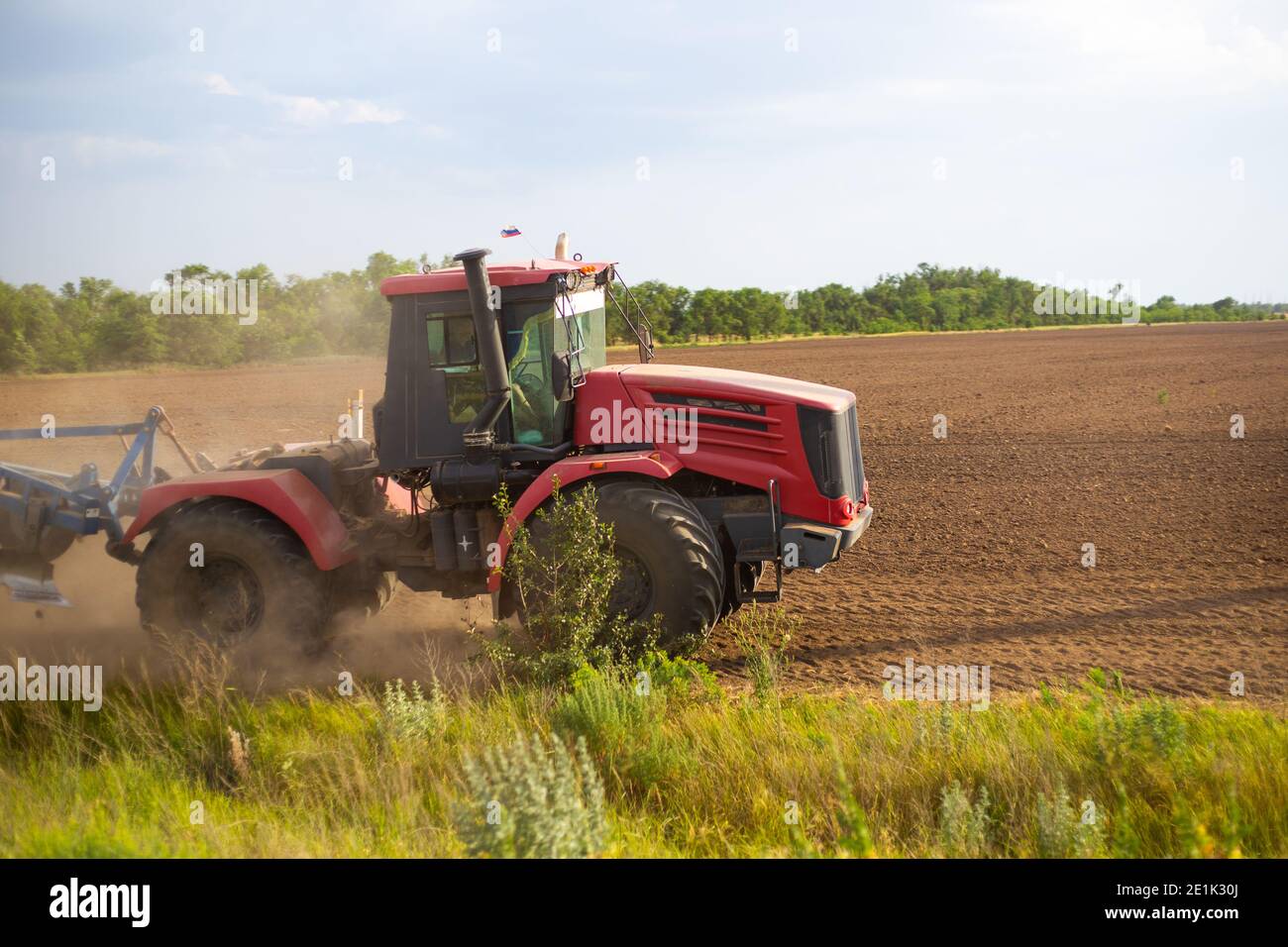 tractor plows the land for sowing, with a plow on a sunny day ...