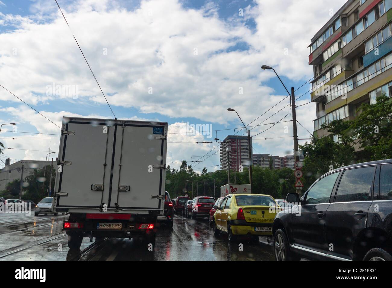 Traffic in cloudy rainy day with road view through car front window in ...