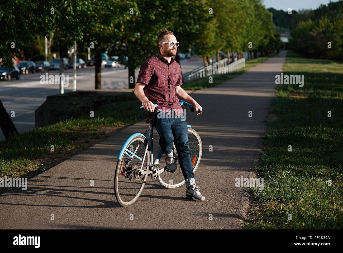 A handsome male with bicycle and backpack Stock Photo - Alamy