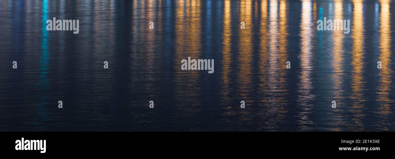 Water texture with colored lights reflected in it at night. Abstract ...