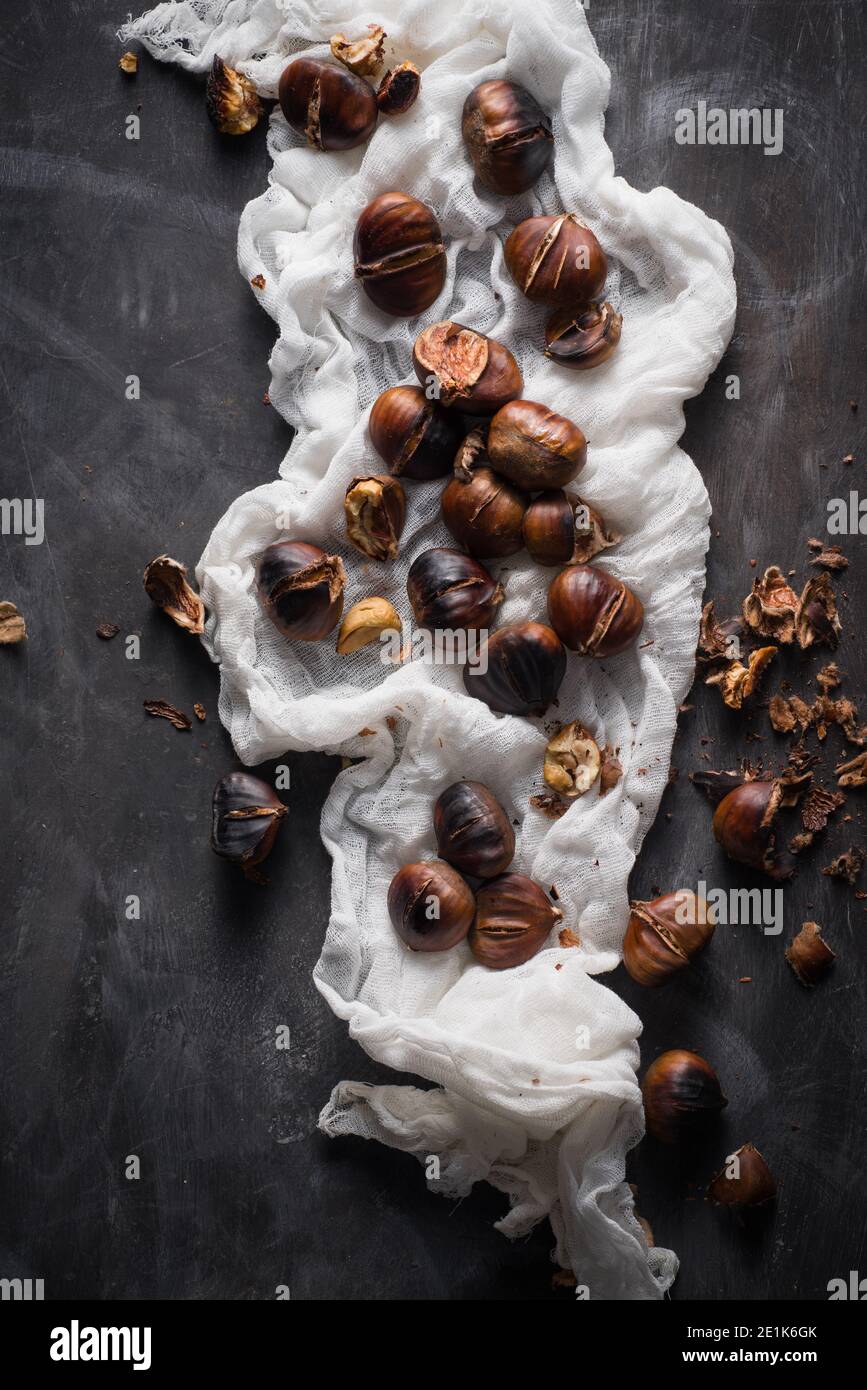 Roasted chestnut shot on an old white cloth and black background Stock ...