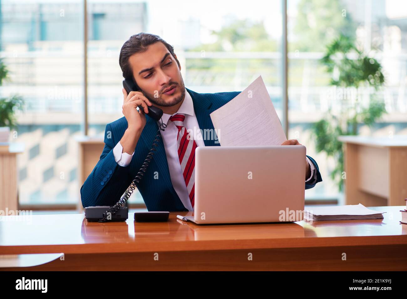 Young attractive male employee working in the office Stock Photo - Alamy