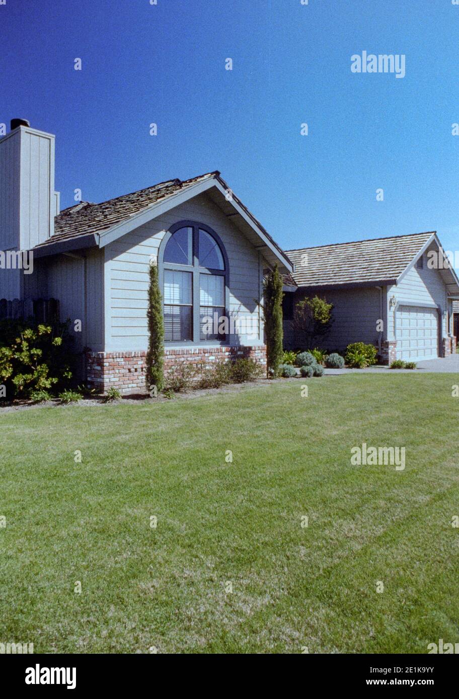 A middle-class house in California has a large front lawn, USA 1989 ...