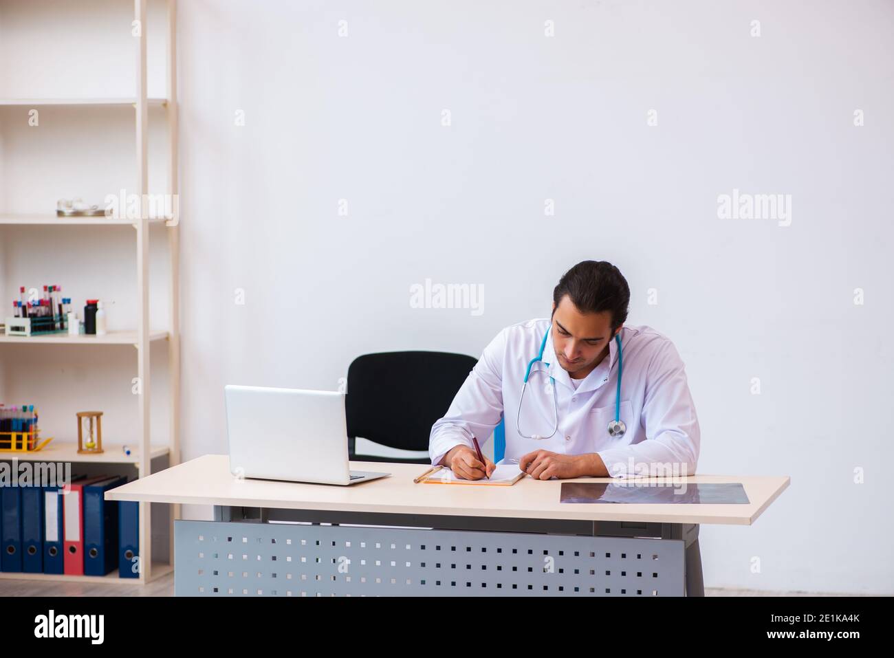 Young doctor taking notes in the clinic Stock Photo - Alamy