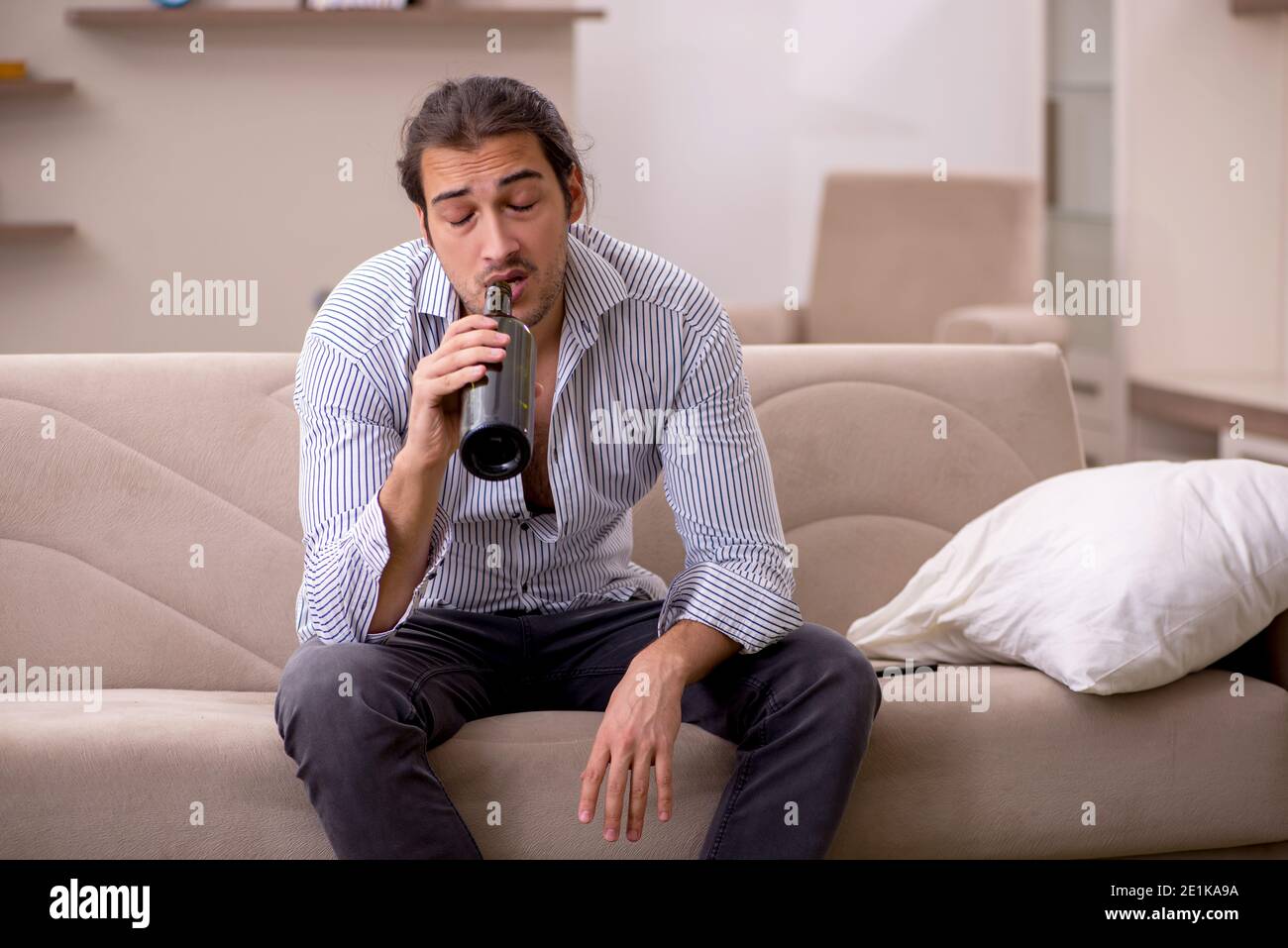 Young drunken man suffering at home Stock Photo - Alamy