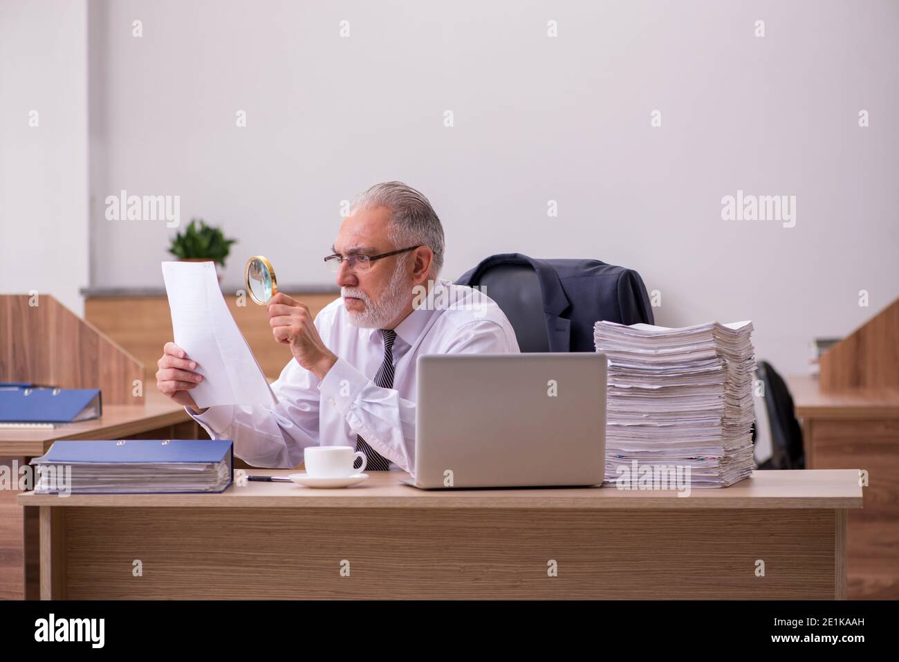 Old employee reading paper in the office Stock Photo - Alamy
