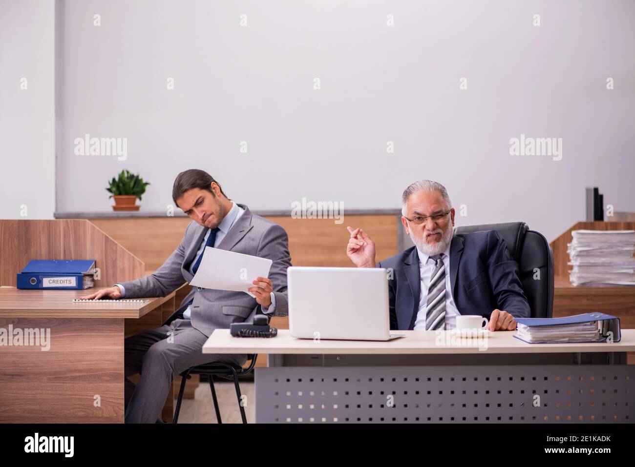 Old male boss and young male assistant in the office Stock Photo - Alamy