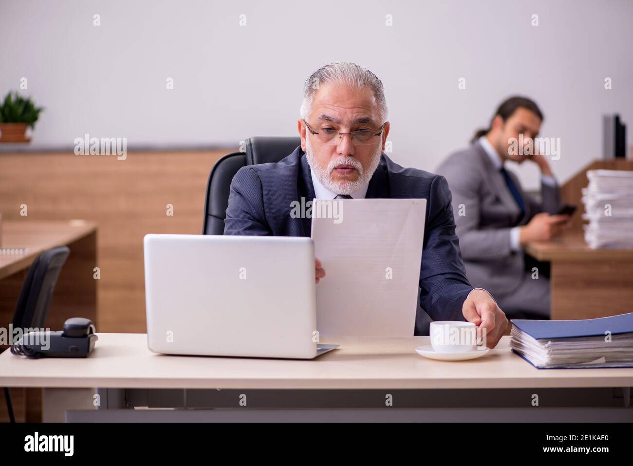 Old male boss and young male assistant in the office Stock Photo - Alamy