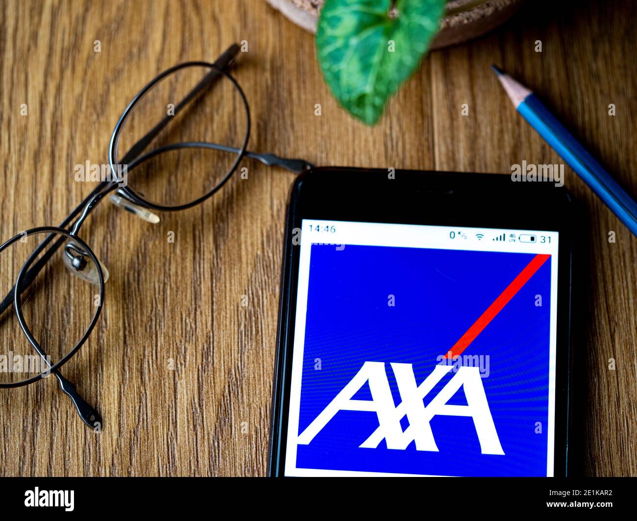 In this photo illustration an AXA Group, logo seen displayed on a ...