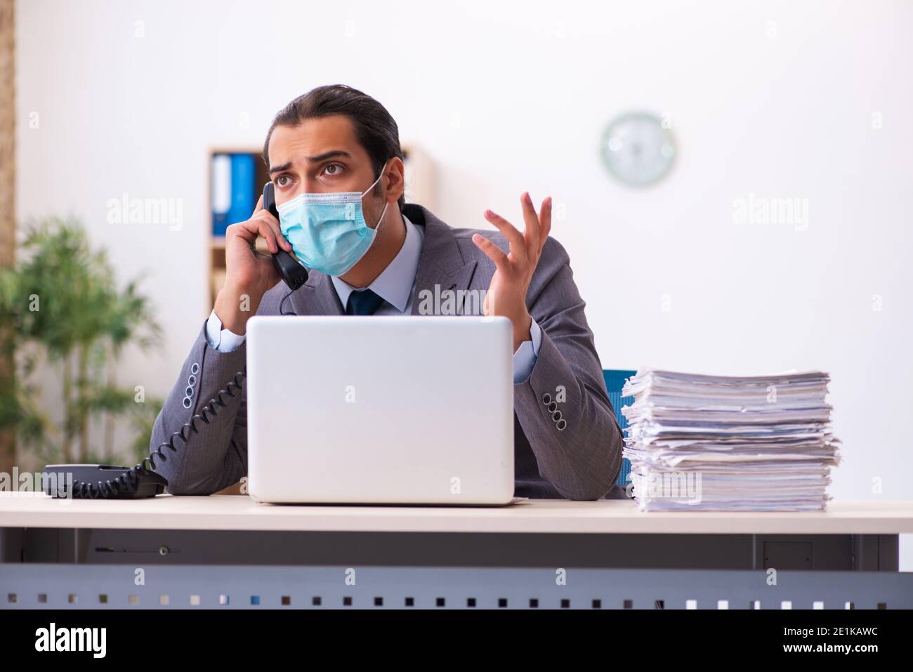 Young employee wearing mask during pandemic Stock Photo - Alamy
