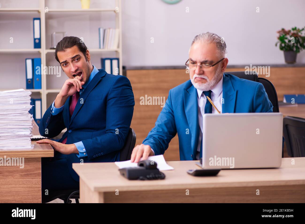 Old boss and his young male assistant in bullying concept Stock Photo ...