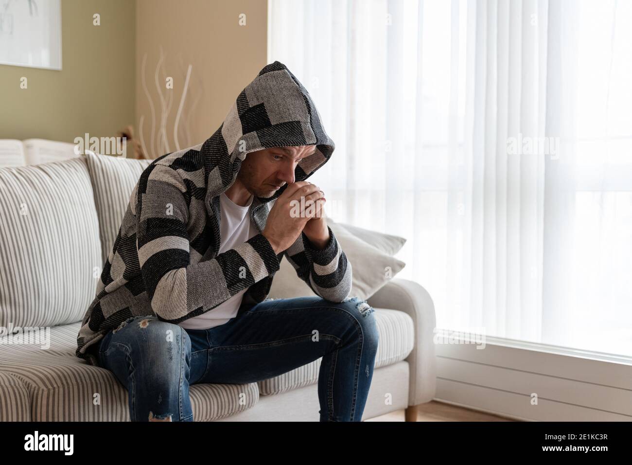 Lifestyle dramatic light portrait of young sad and depressed man ...