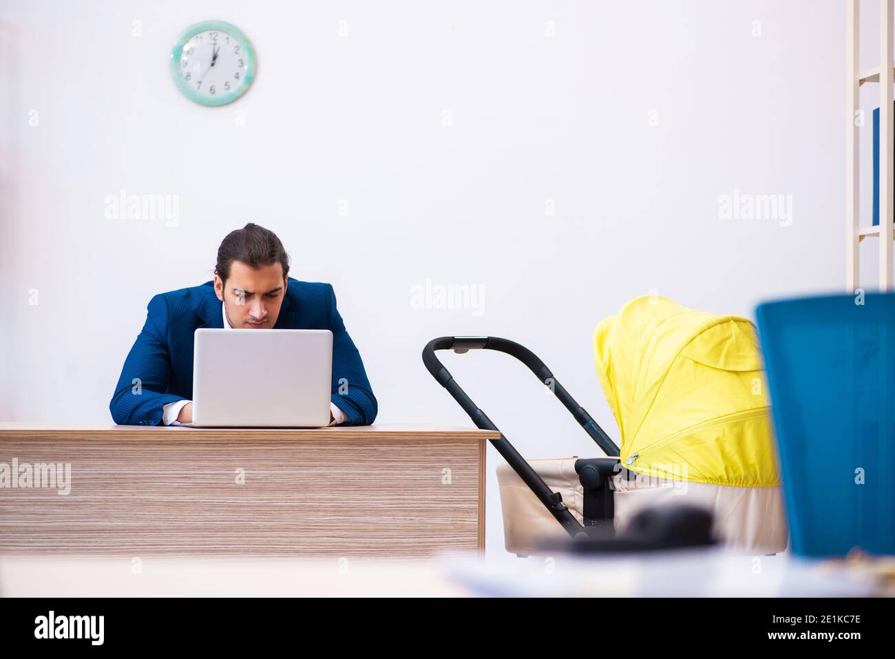 Young employee looking after kid at workplace Stock Photo - Alamy