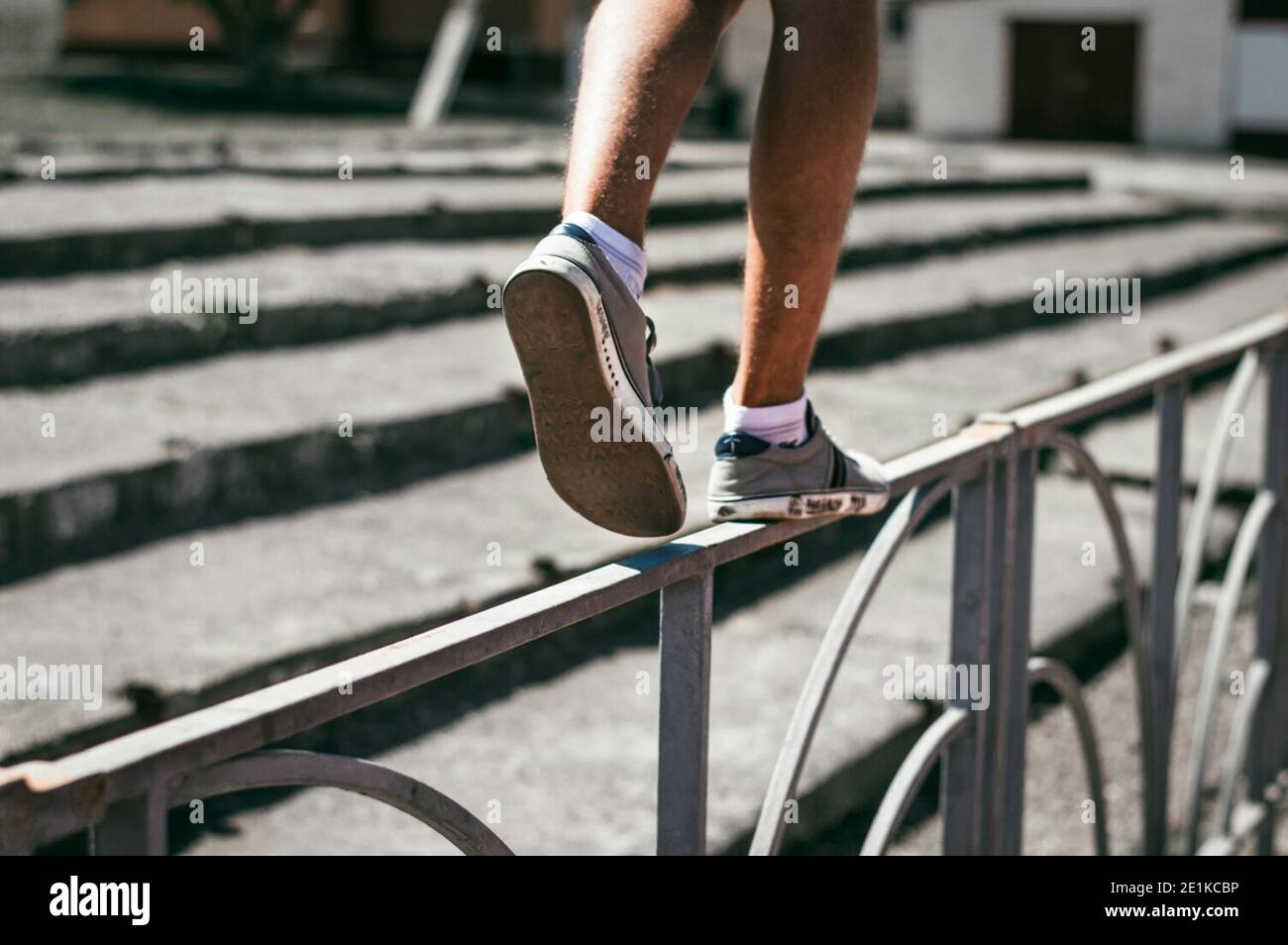 The guy in the sneakers is walking on the fence. Climb over the fence ...