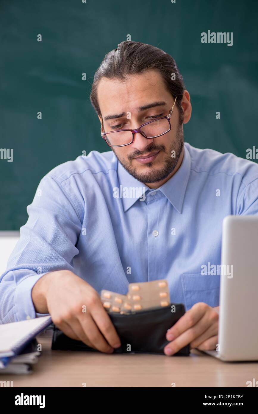 Young sick teacher in the classroom Stock Photo - Alamy